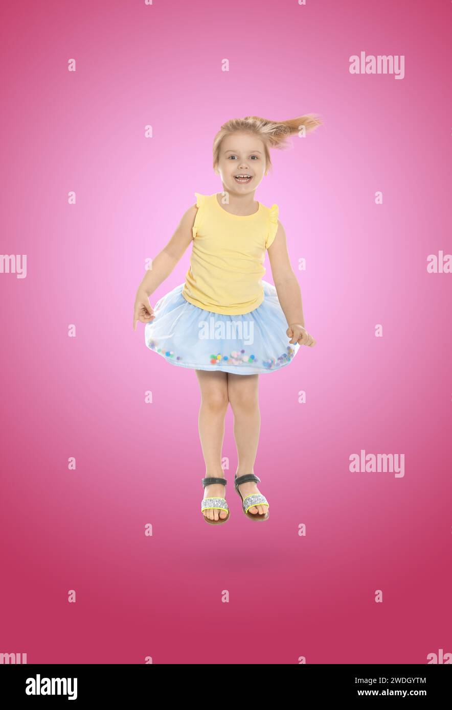 Happy cute girl jumping on color gradient background Stock Photo - Alamy