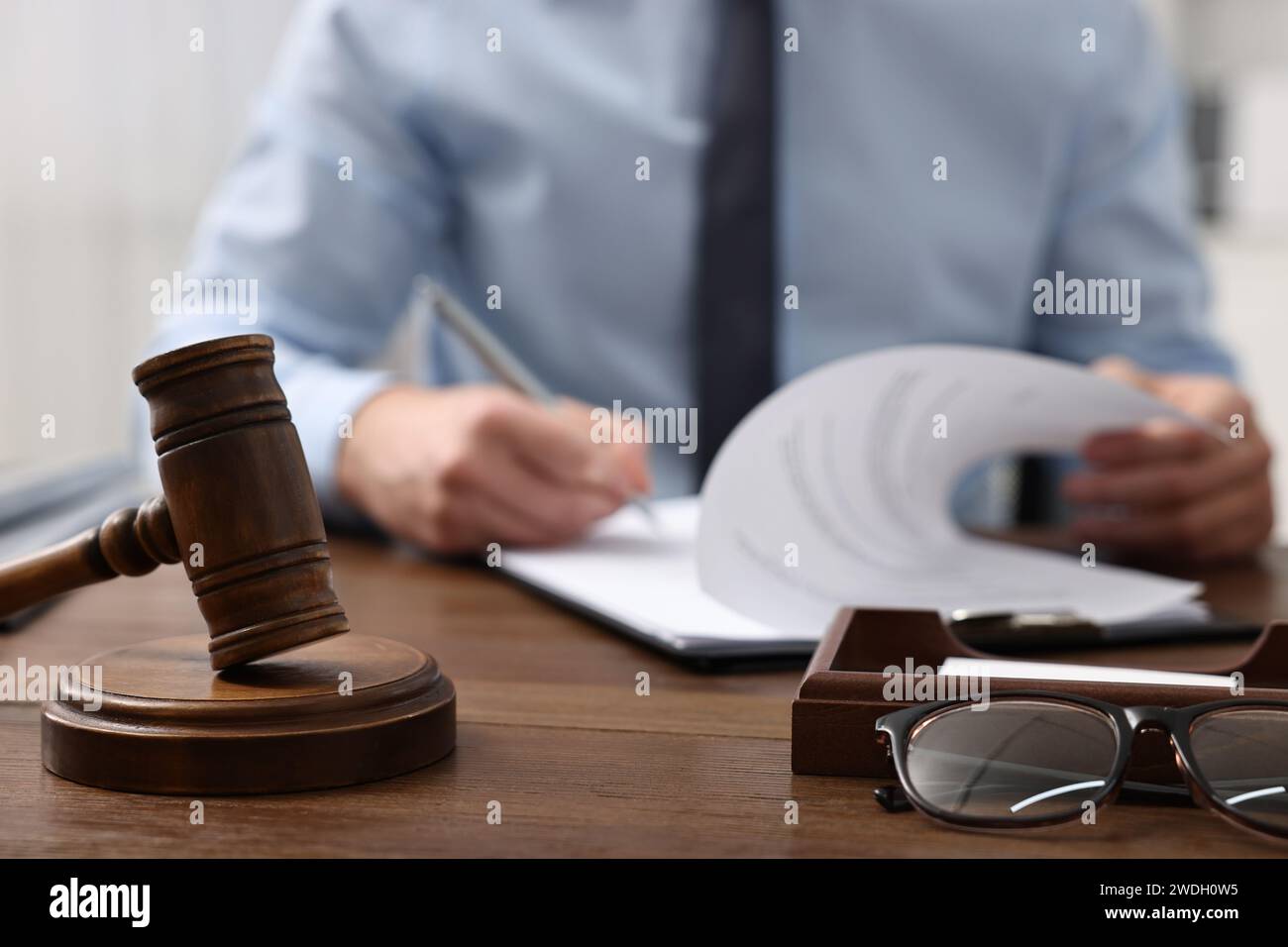Lawyer working at wooden table indoors, focus on gavel Stock Photo - Alamy