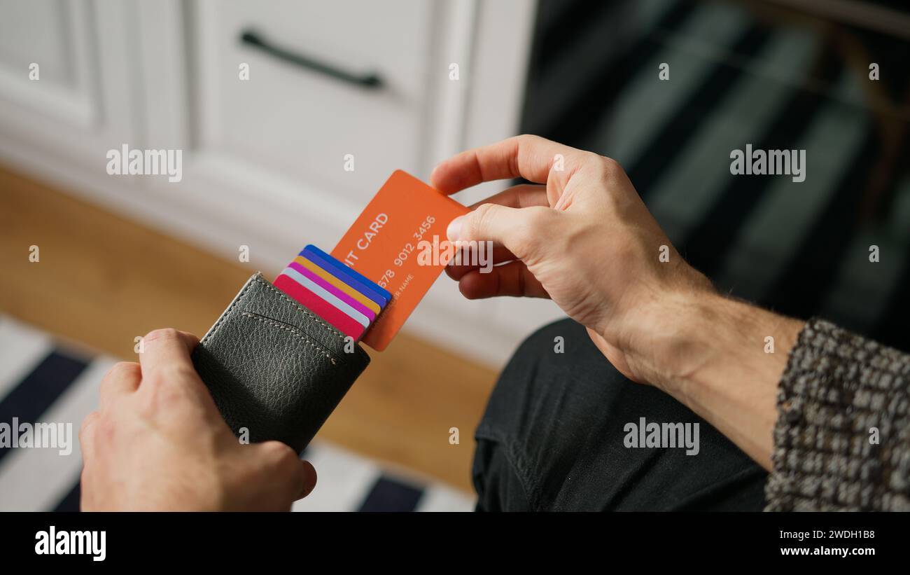 Close-up of young man hand opens card wallet full of credit cards ...