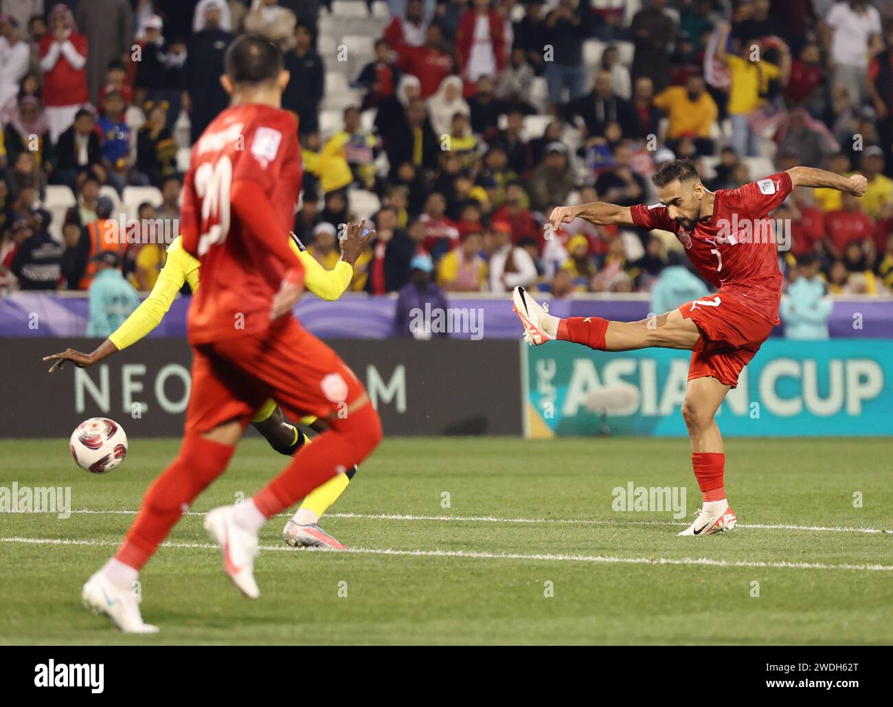 Doha, Qatar. 20th Jan, 2024. Ali Madan (R) of Bahrain shoots to score ...