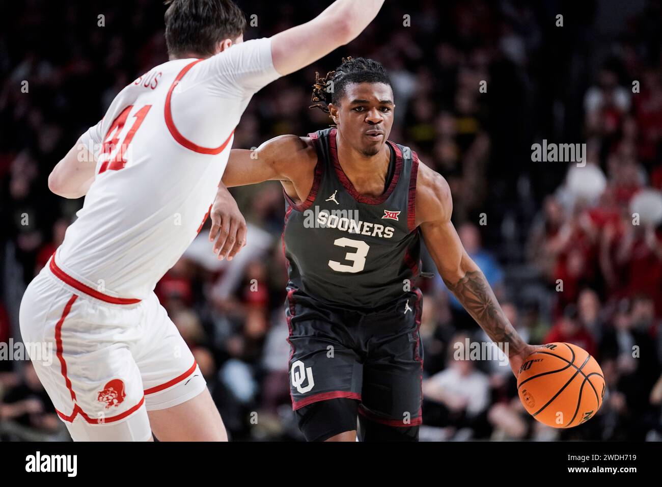 Oklahoma guard Otega Oweh, right, dribbles the ball as Cincinnati guard ...