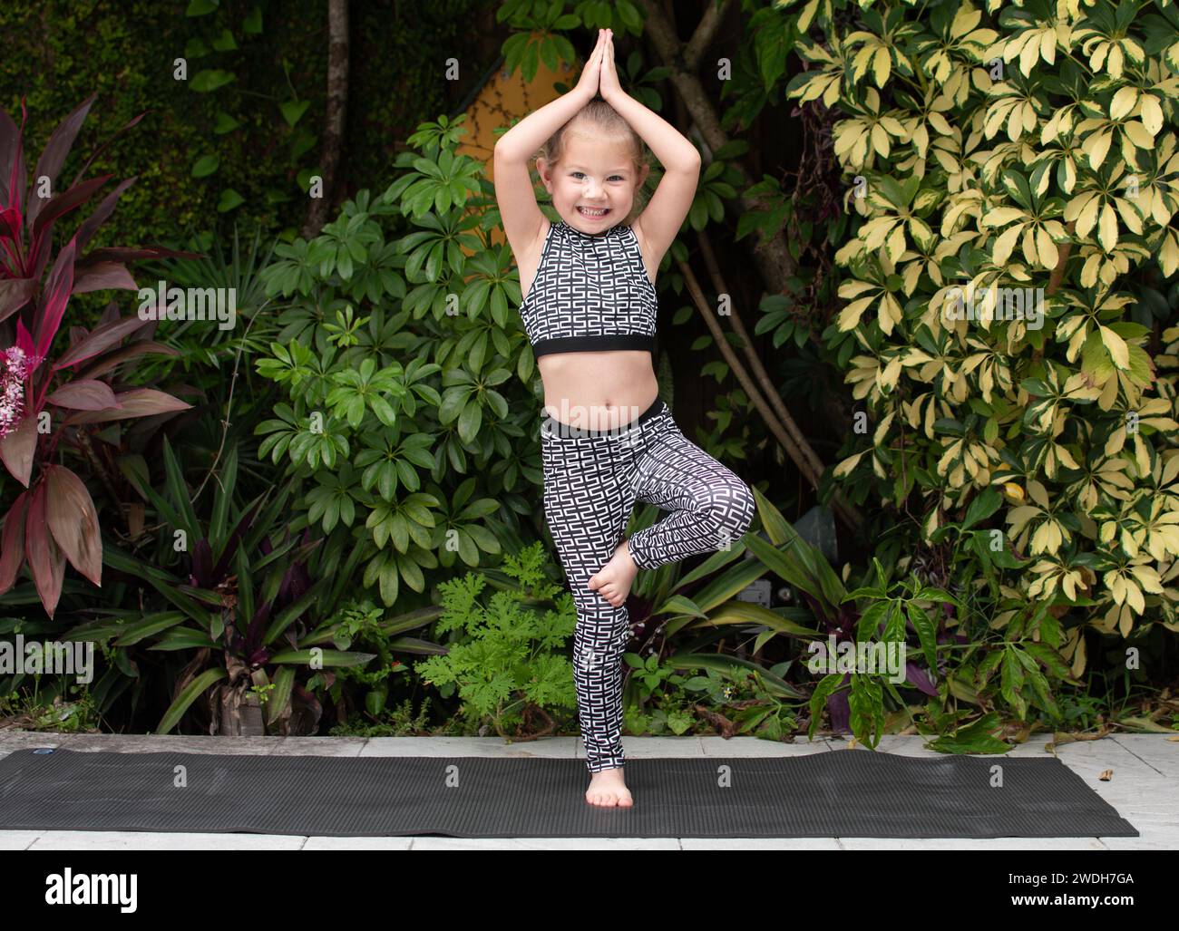 Little girl doing yoga tree pose. Preschooler practicing yoga Stock ...