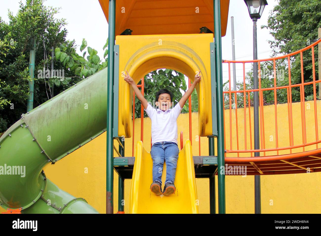 9-year-old dark-skinned Latino boy plays in a playground as a physical ...