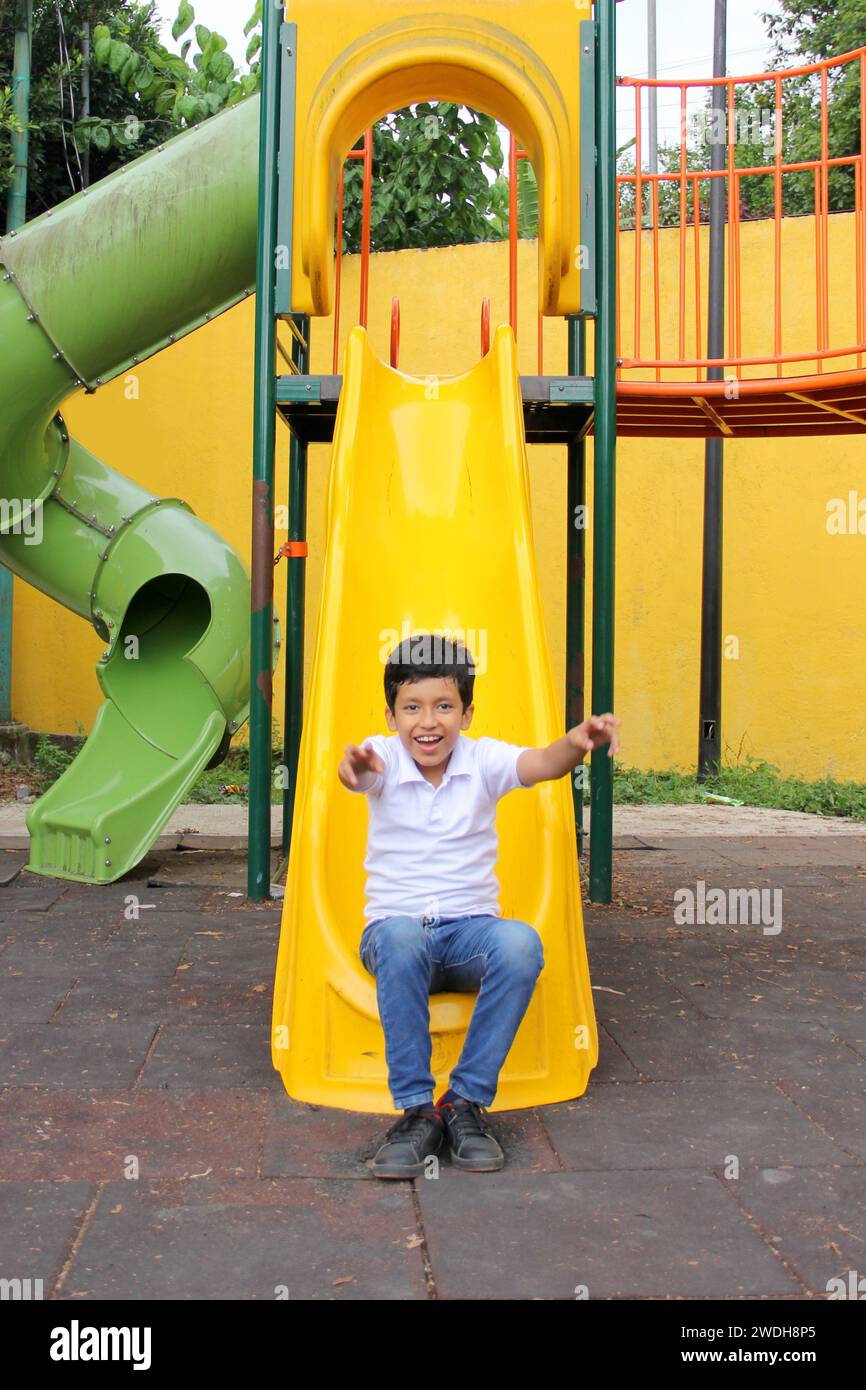 9-year-old dark-skinned Latino boy plays in a playground as a physical ...