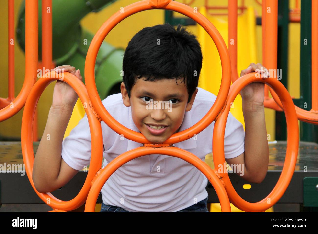 9-year-old dark-skinned Latino boy plays in a playground as a physical ...
