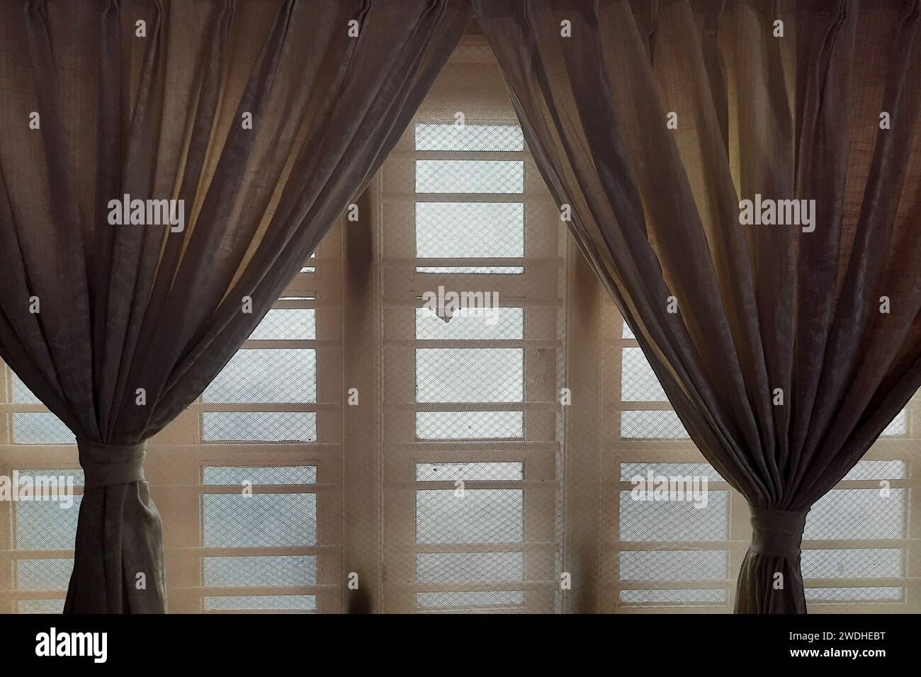 View of closed window with frosted glass panes and banded curtains in ...