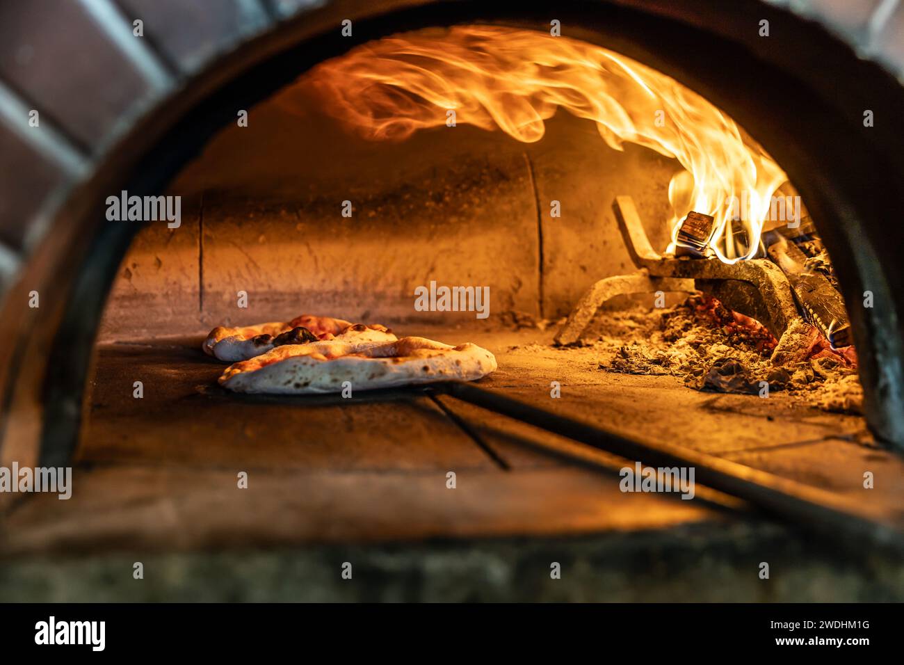 Traditional oven for baking pizza with burning wood and shovel. The ...