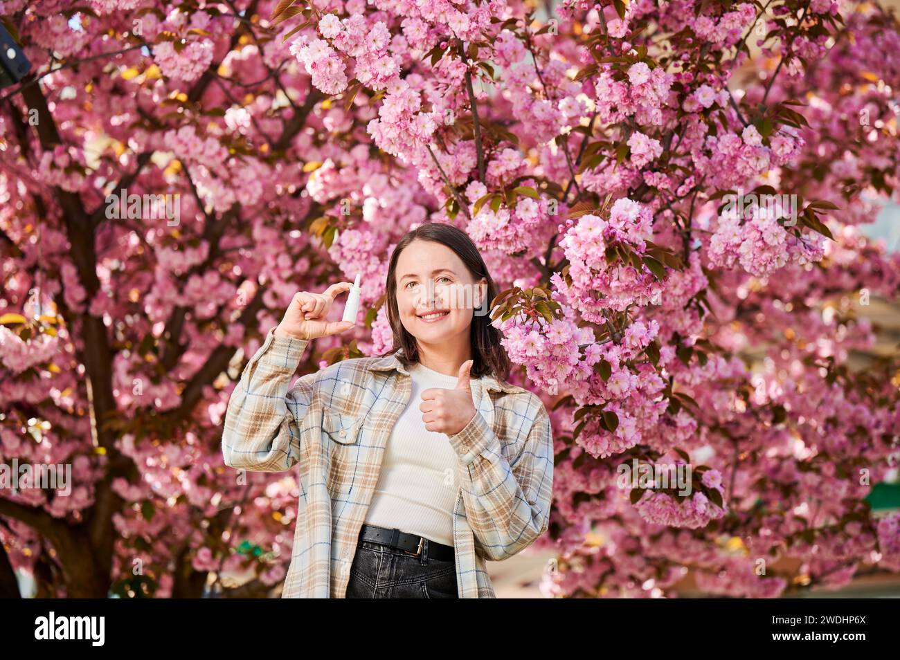 Woman allergic holding medical nasal spray, suffering from seasonal ...
