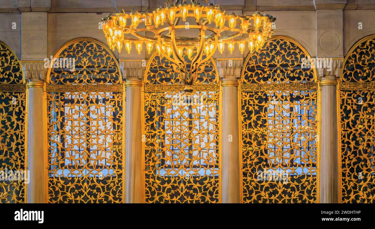 Istanbul, Turkey - November 8, 2023: Ornate floral gold arch decor and a chandelier inside the ...