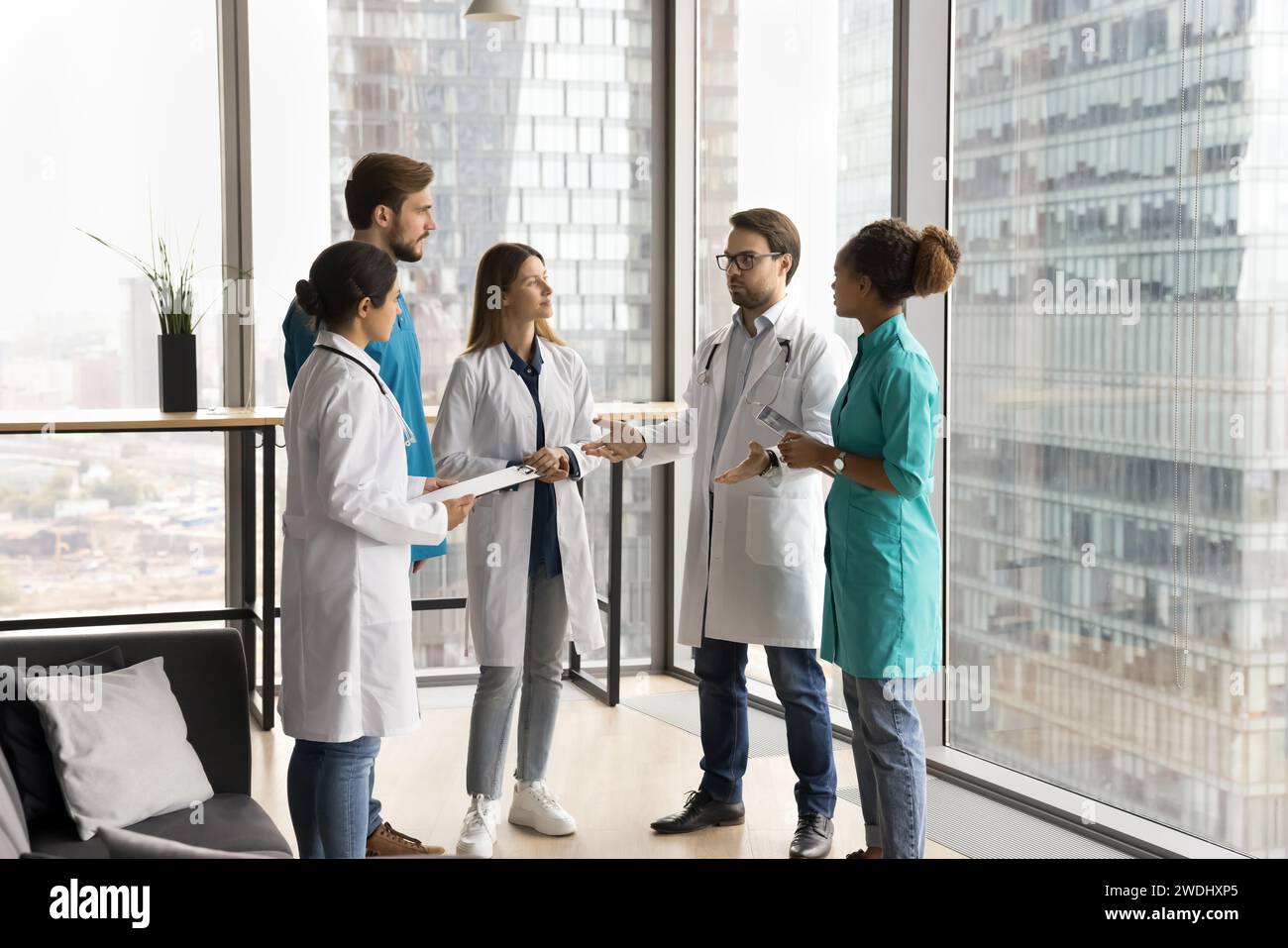 City hospital head doctor talking to medical staff in hall Stock Photo ...