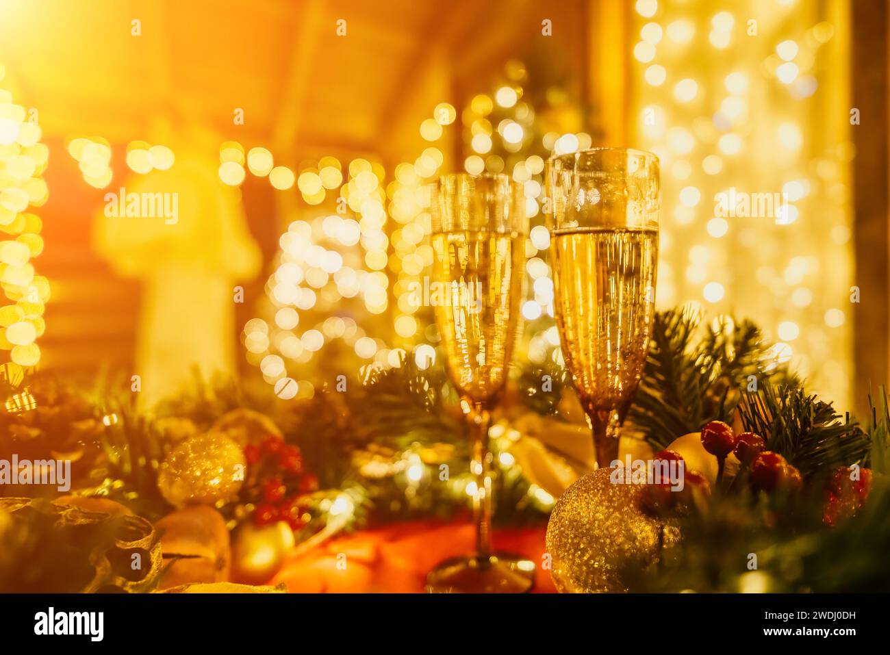 Two champagne glasses filled with champagne are placed on a table near ...