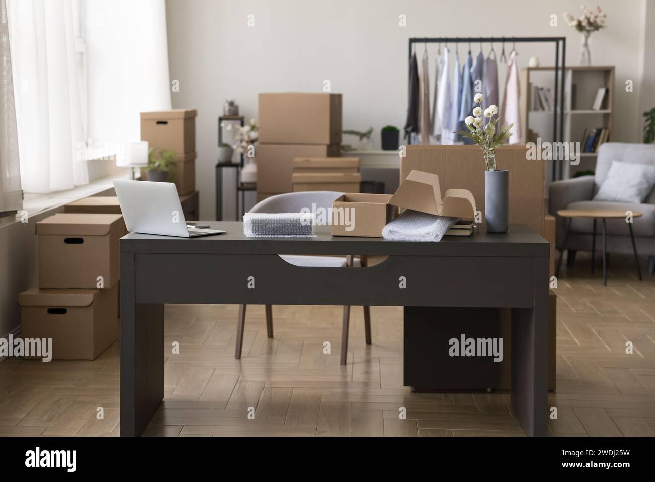 Workplace with desk and heap of cardboard boxes Stock Photo - Alamy