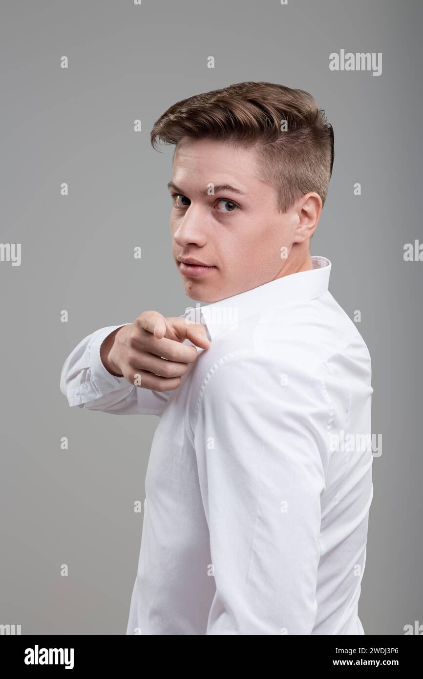 Over-the-shoulder glance reveals young man's confidence and modern ...