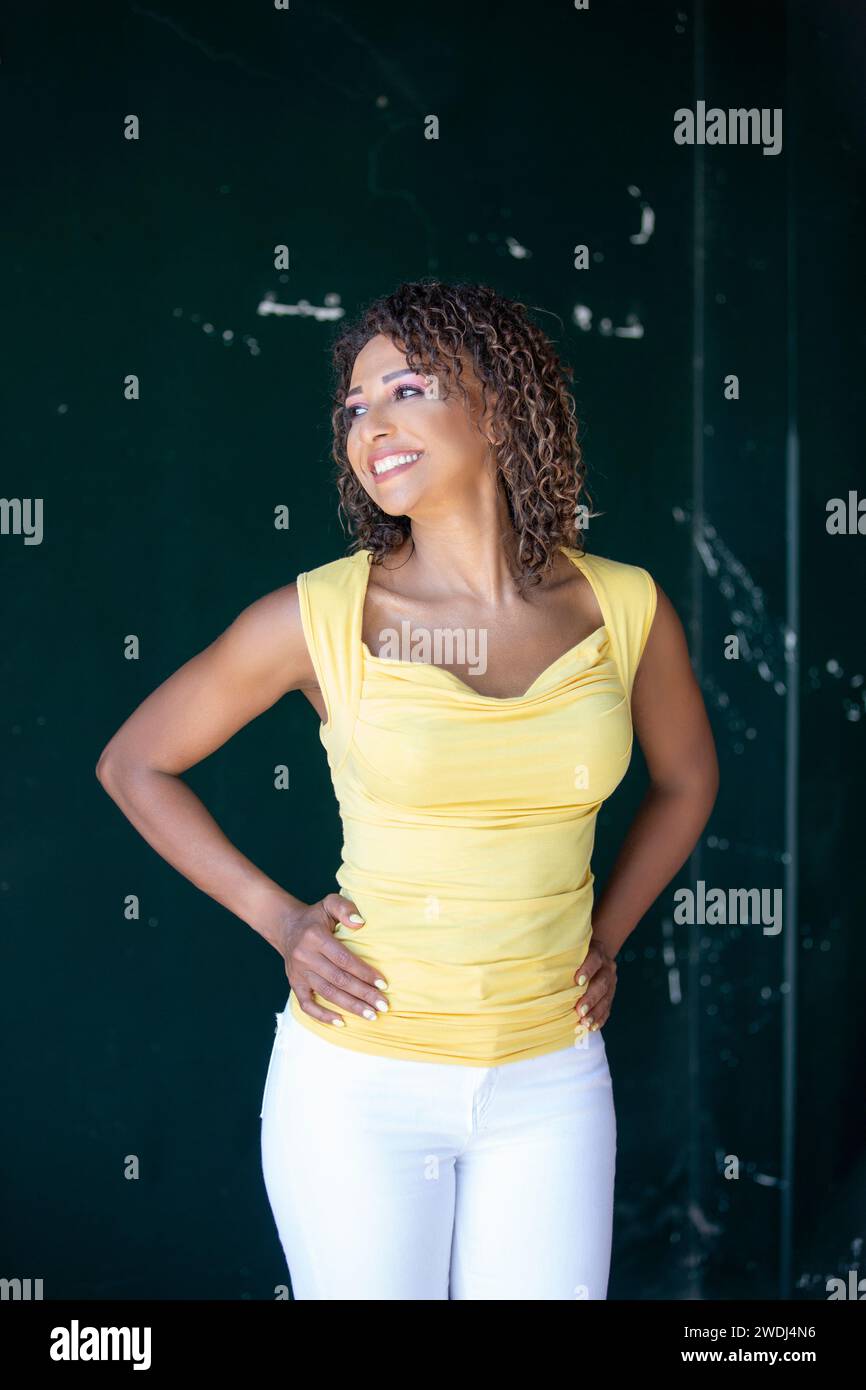 Happy woman hands on hips looking away smiling Stock Photo - Alamy