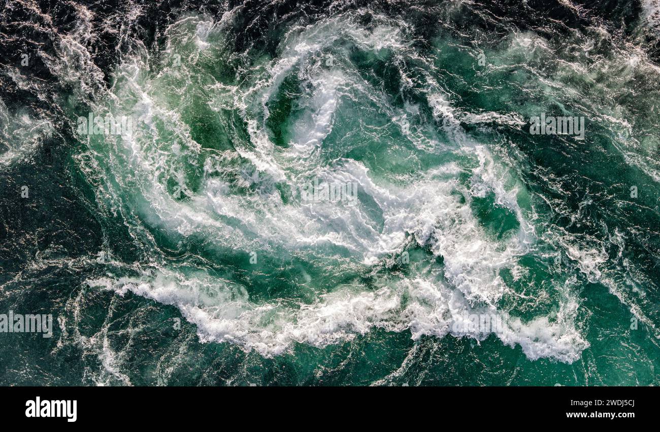 Blue waves of water of the river and the sea meet each other during ...