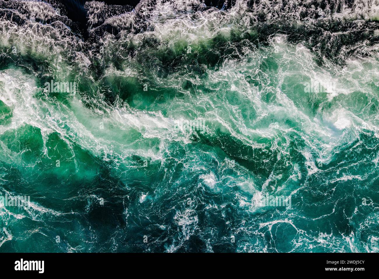 Blue waves of water of the river and the sea meet each other during ...