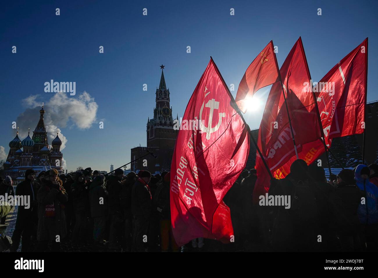 Russian Communist supporters carry red flags as they walk to lay ...