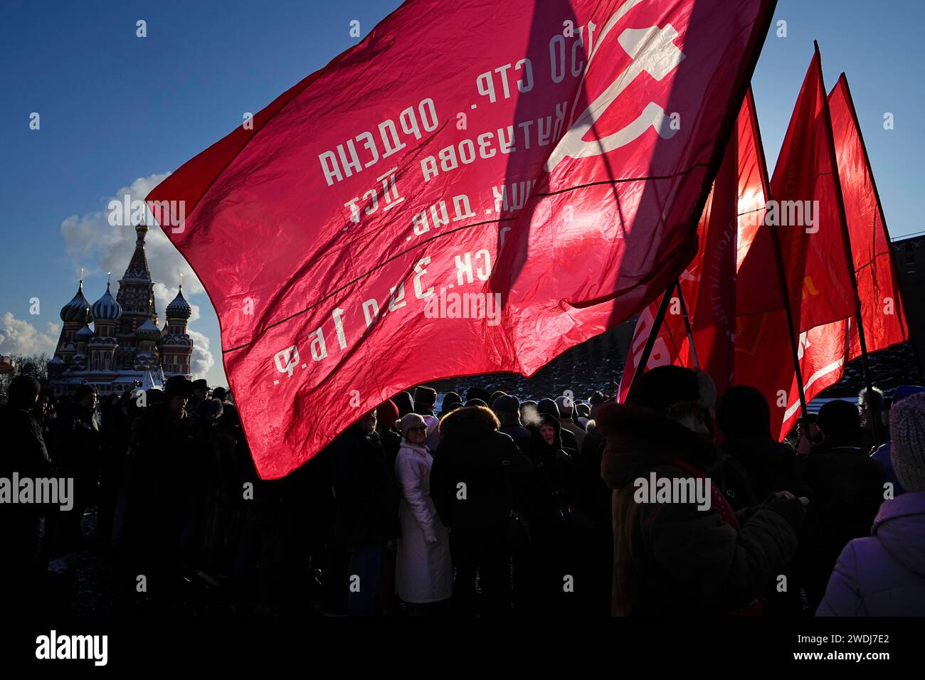 Russian Communist supporters carry red flags as they walk to lay ...