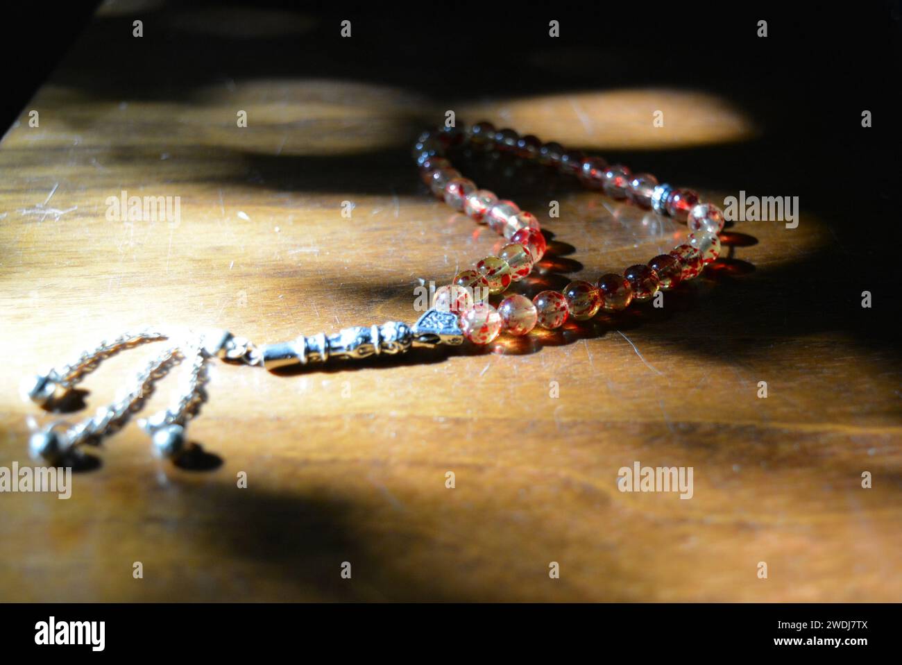 Muslim religious beads of yellow and red beads on a lacquered wooden ...
