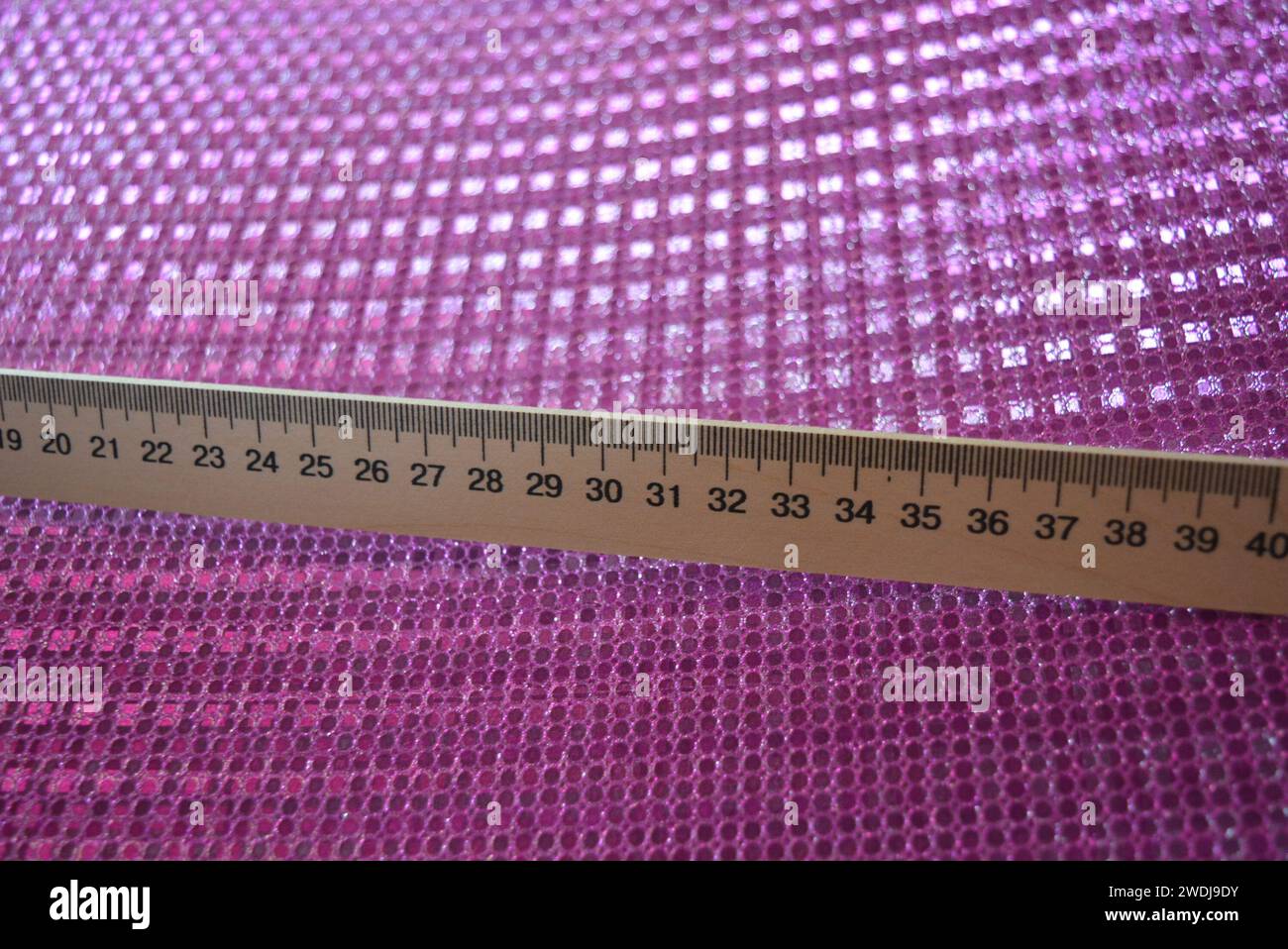 A light wooden mathematical ruler on a pink reflective background Stock ...
