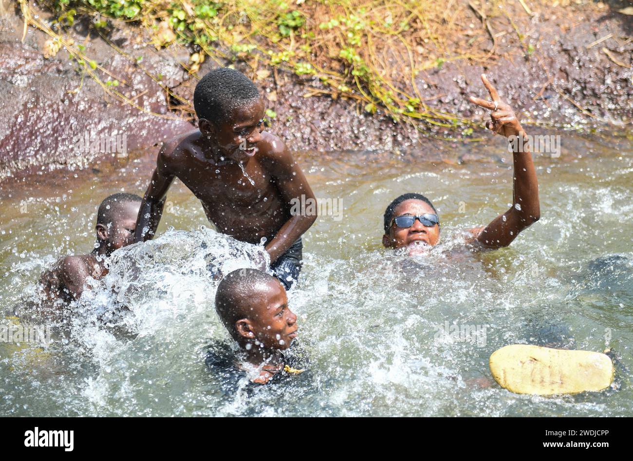 Anie, Togo. 14th Jan, 2024. Villagers play in water to cool themselves ...