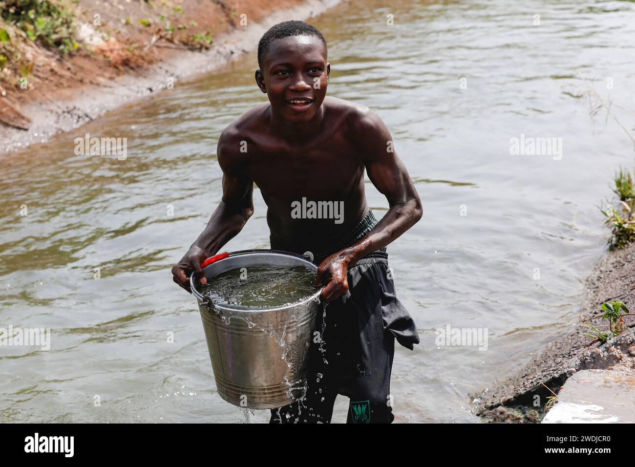 Anie, Togo. 14th Jan, 2024. A villager fetches water from an irrigation ...