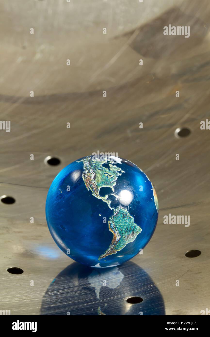 An Earth globe marble in a metal kitchen strainer Stock Photo - Alamy