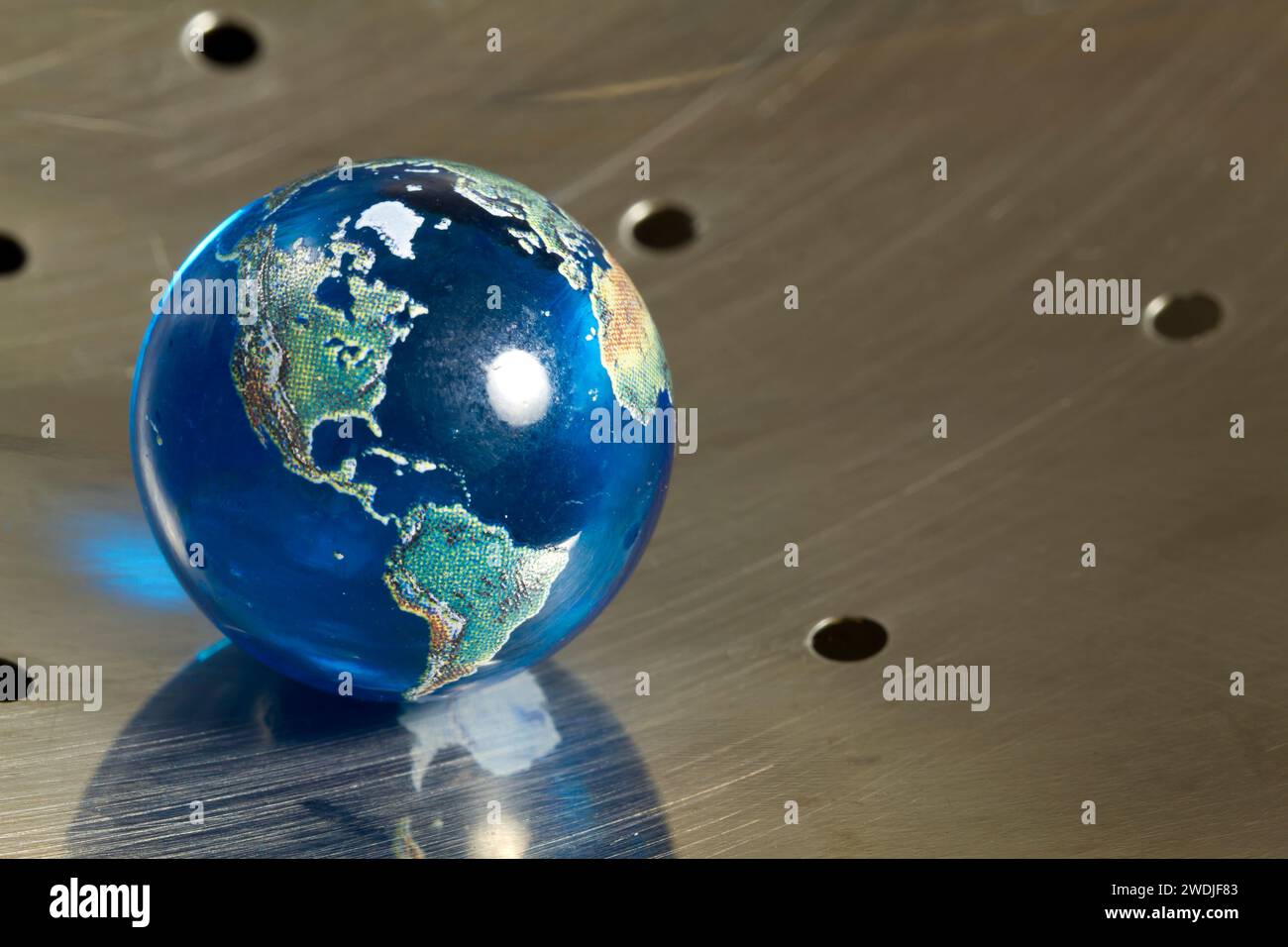 An Earth globe marble in a metal kitchen strainer Stock Photo - Alamy