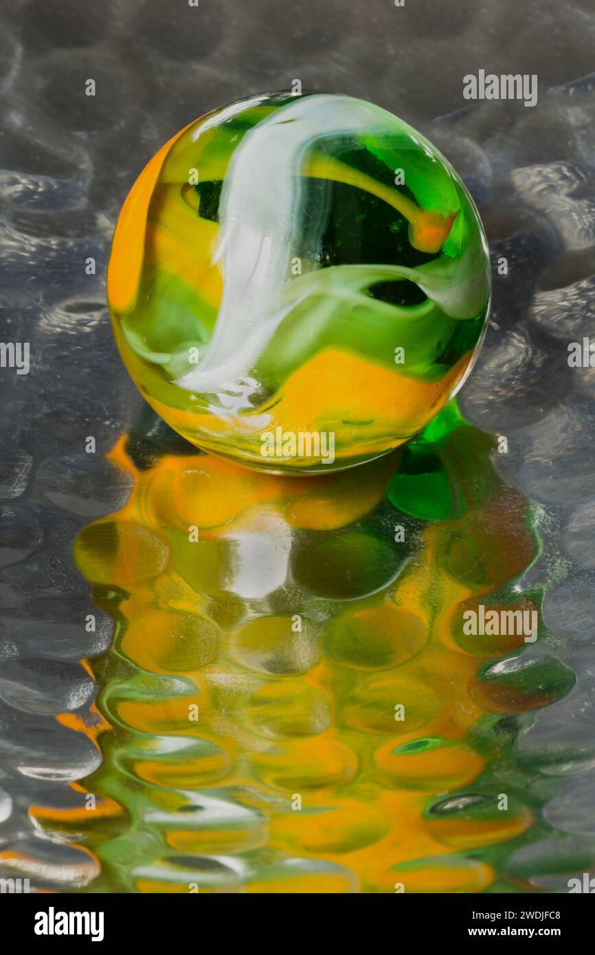 A colorful swirl marble in a metal bowl Stock Photo - Alamy