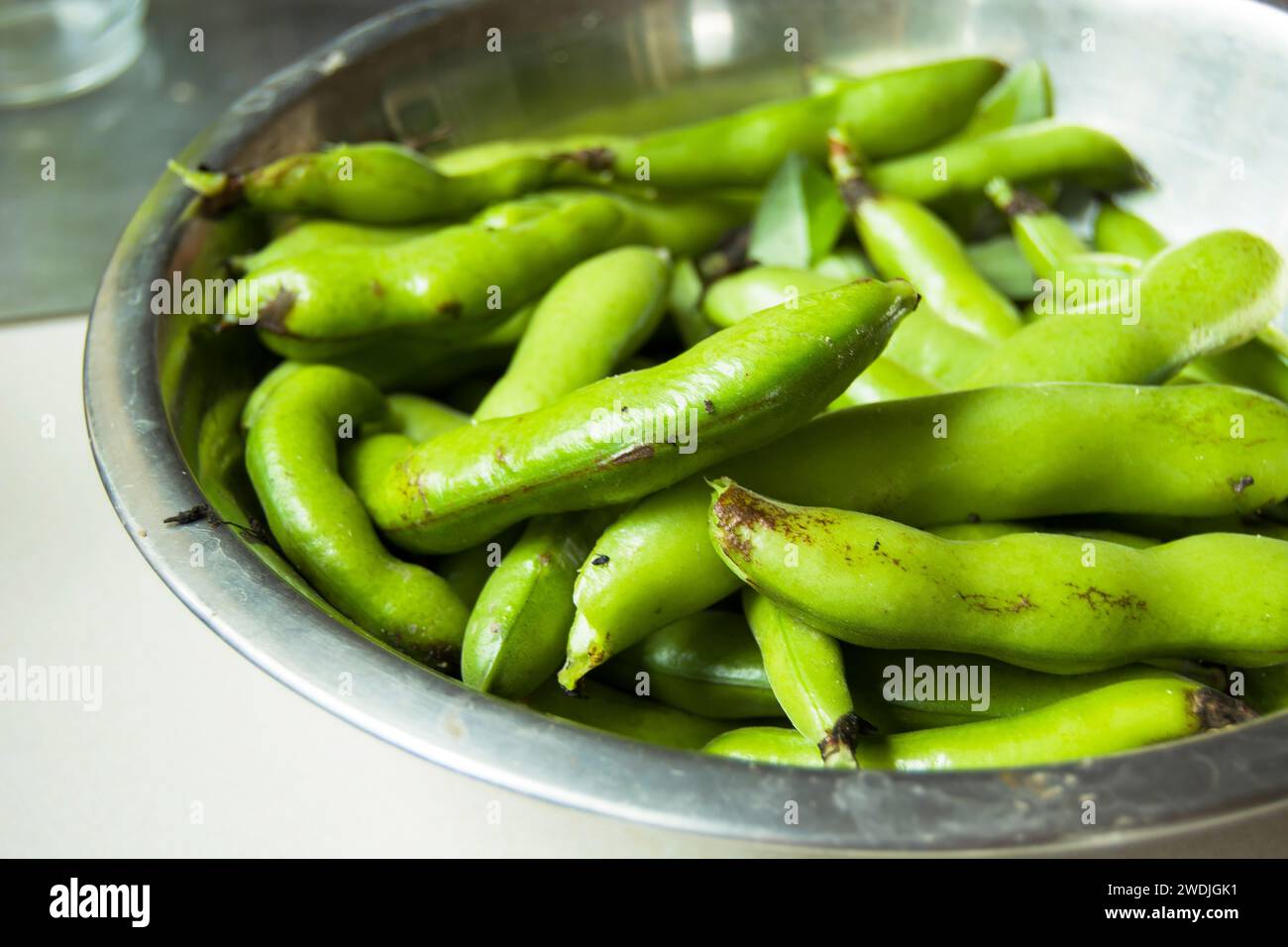 Green pods of vetch broad beans in a silver bowl Stock Photo - Alamy