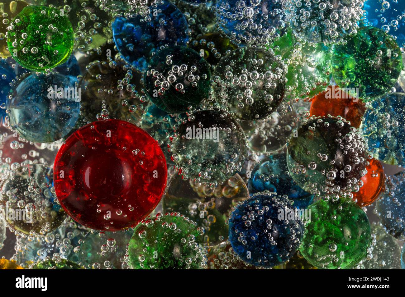 Colorful glass marbles in clear soda Stock Photo - Alamy