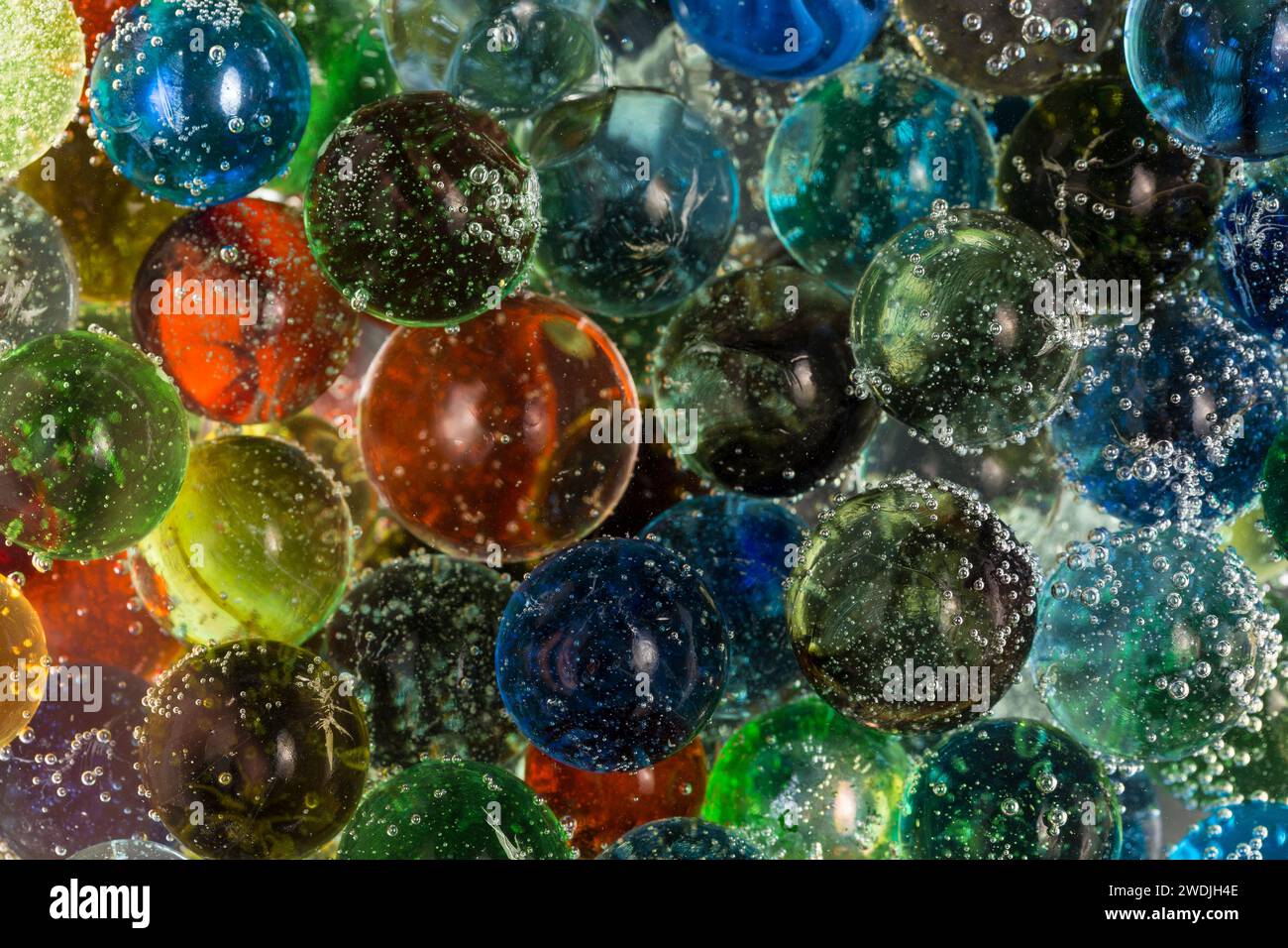 Colorful glass marbles in clear soda Stock Photo - Alamy