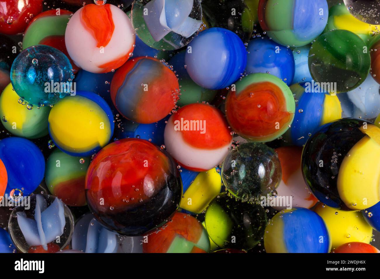 A collection of colorful glass marbles in clear soda Stock Photo - Alamy