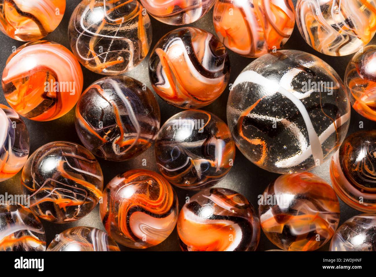 Transparent, orange, black, and white swirl glass marbles Stock Photo ...