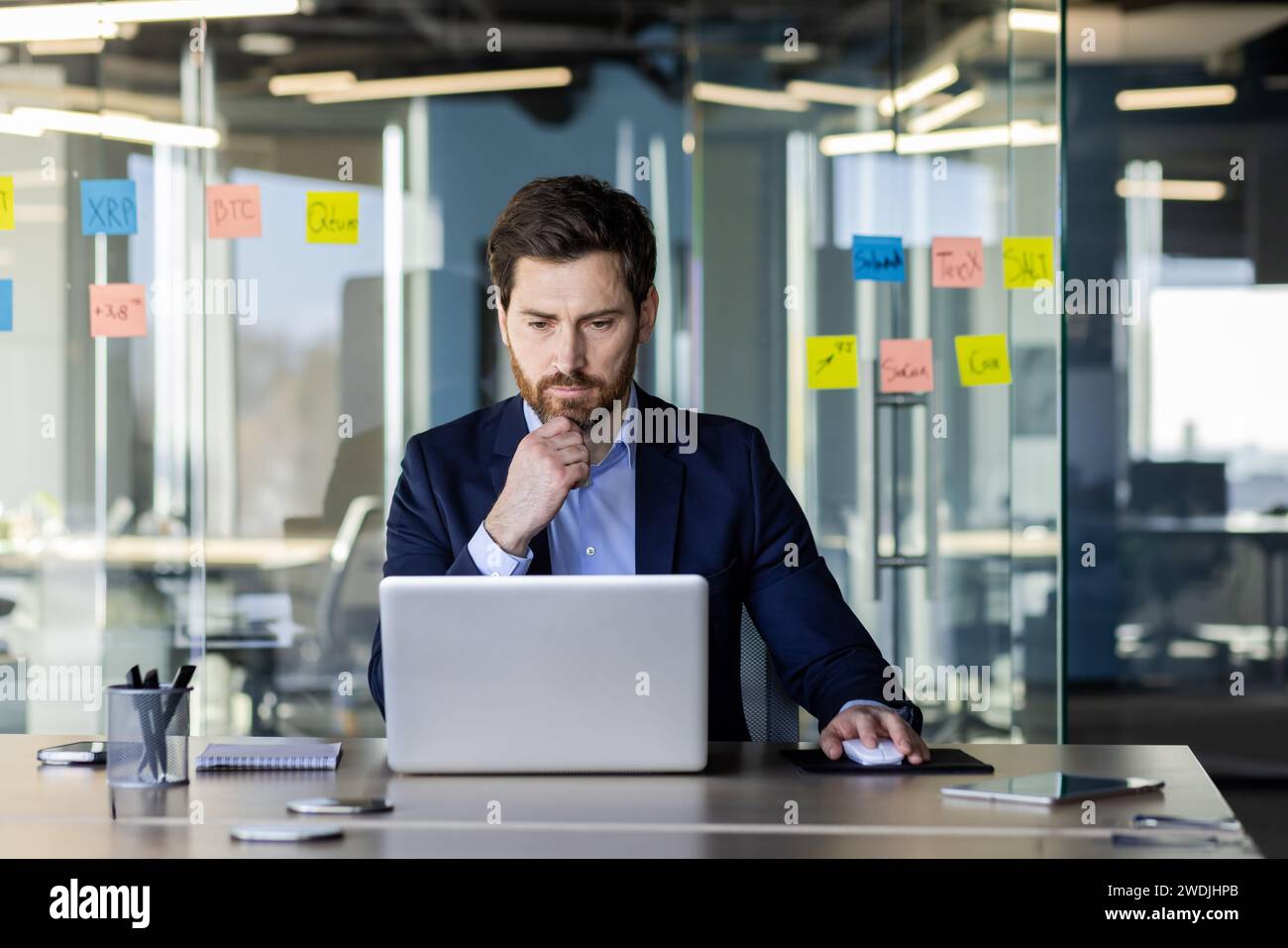 Mature experienced businessman working inside office with laptop ...