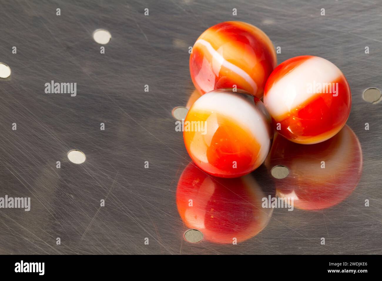 Colorful swirl glass marbles in a metal strainer Stock Photo - Alamy