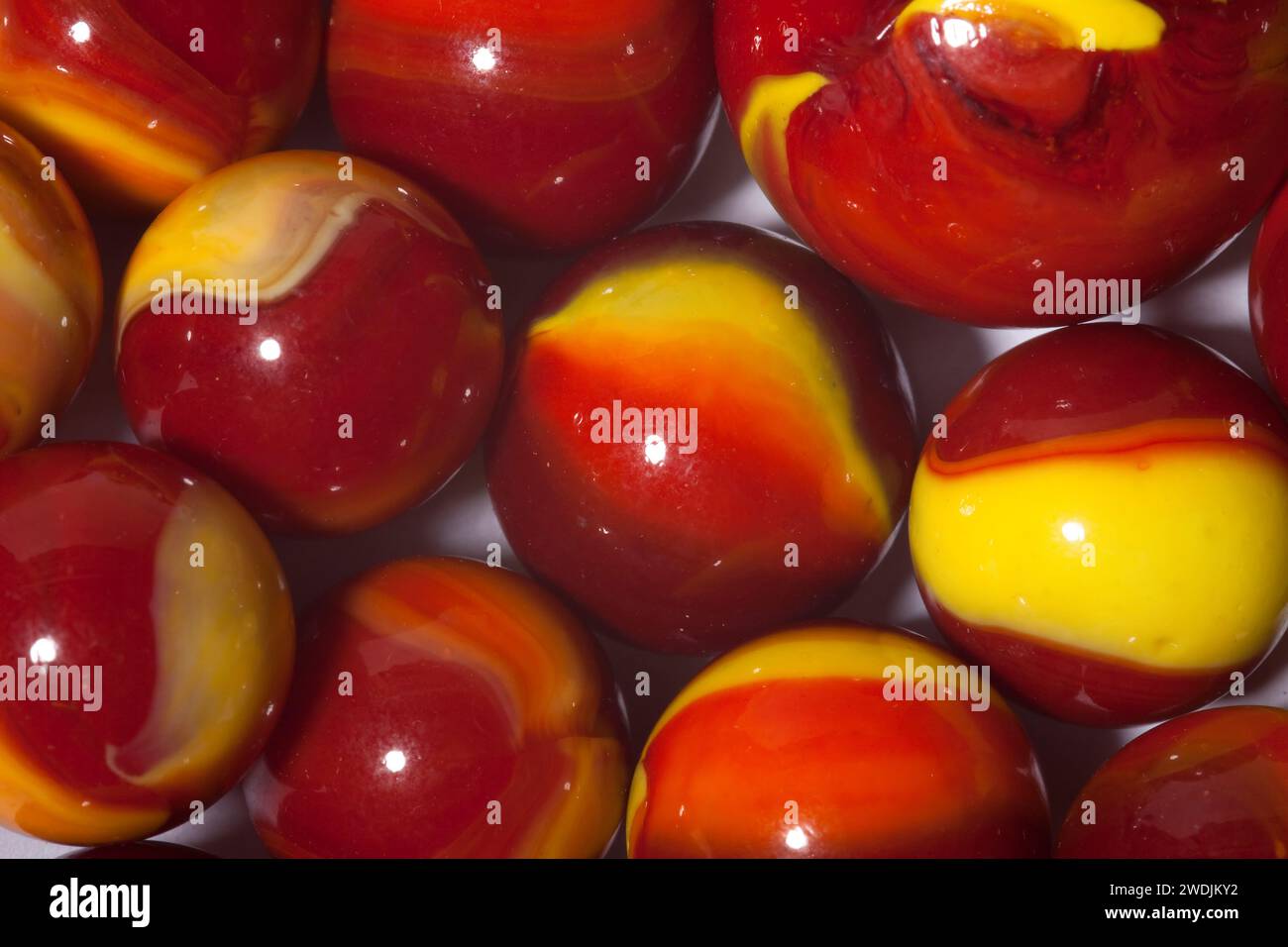 Red, yellow, and orange swirl glass marbles Stock Photo - Alamy