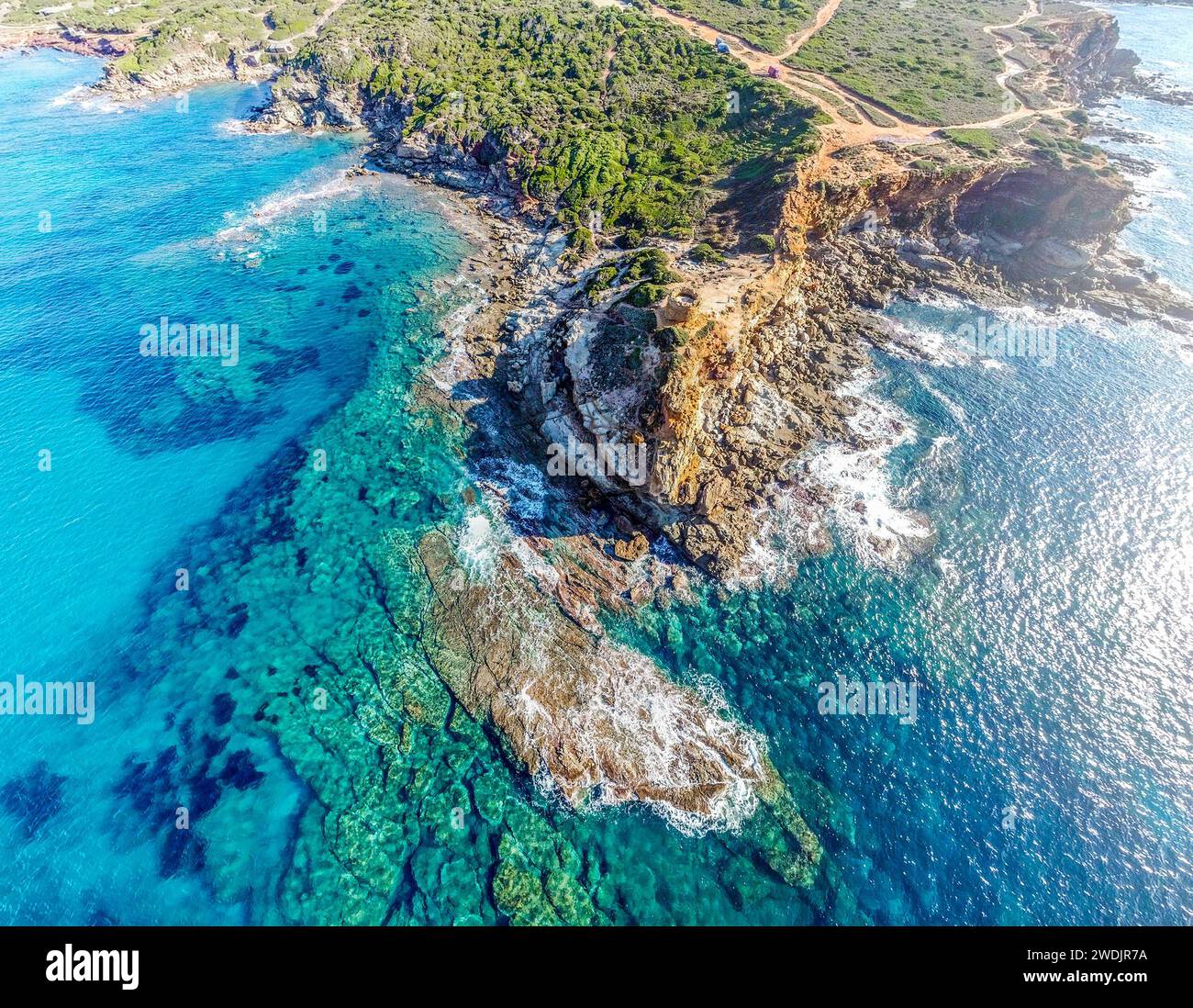 Aerial view of turquoise water and rocks in Porto Ferro coastline ...