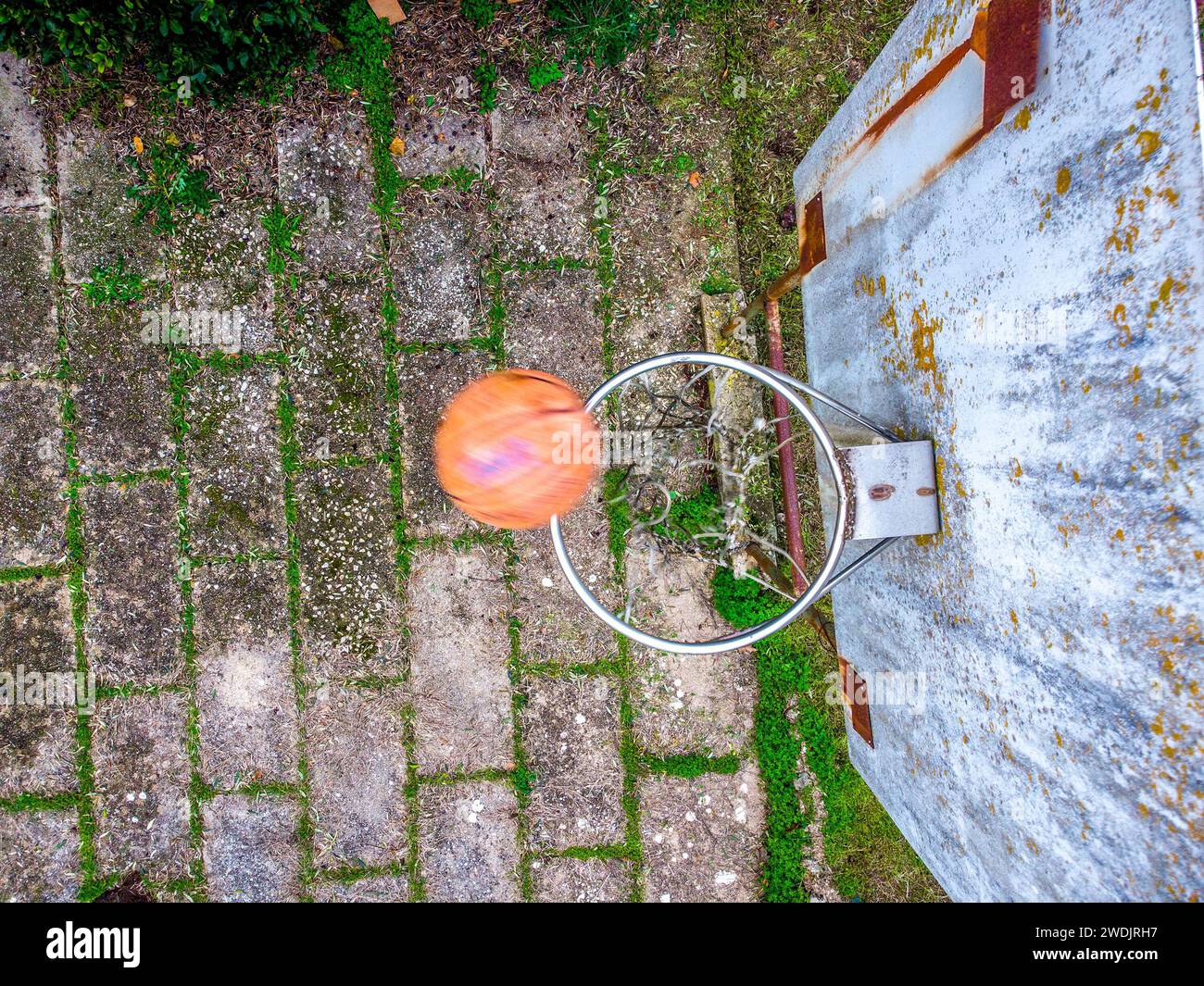 Basketball falling into the hoop in a backyard seen from above Stock ...