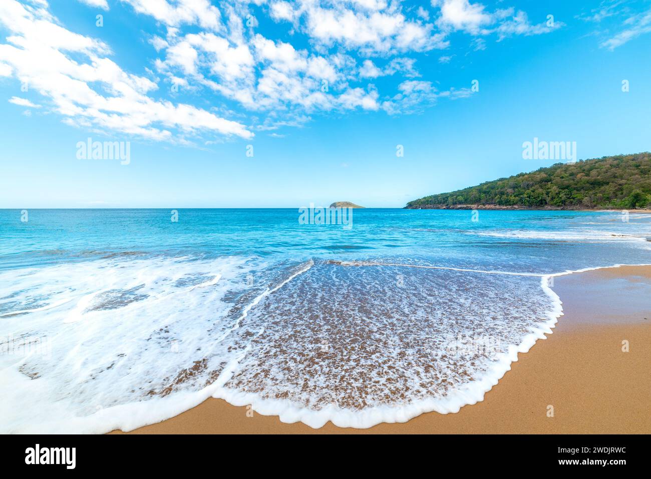Small wave in La Perle beach on a cloudy day. Guadeloupe, Caribbean sea ...