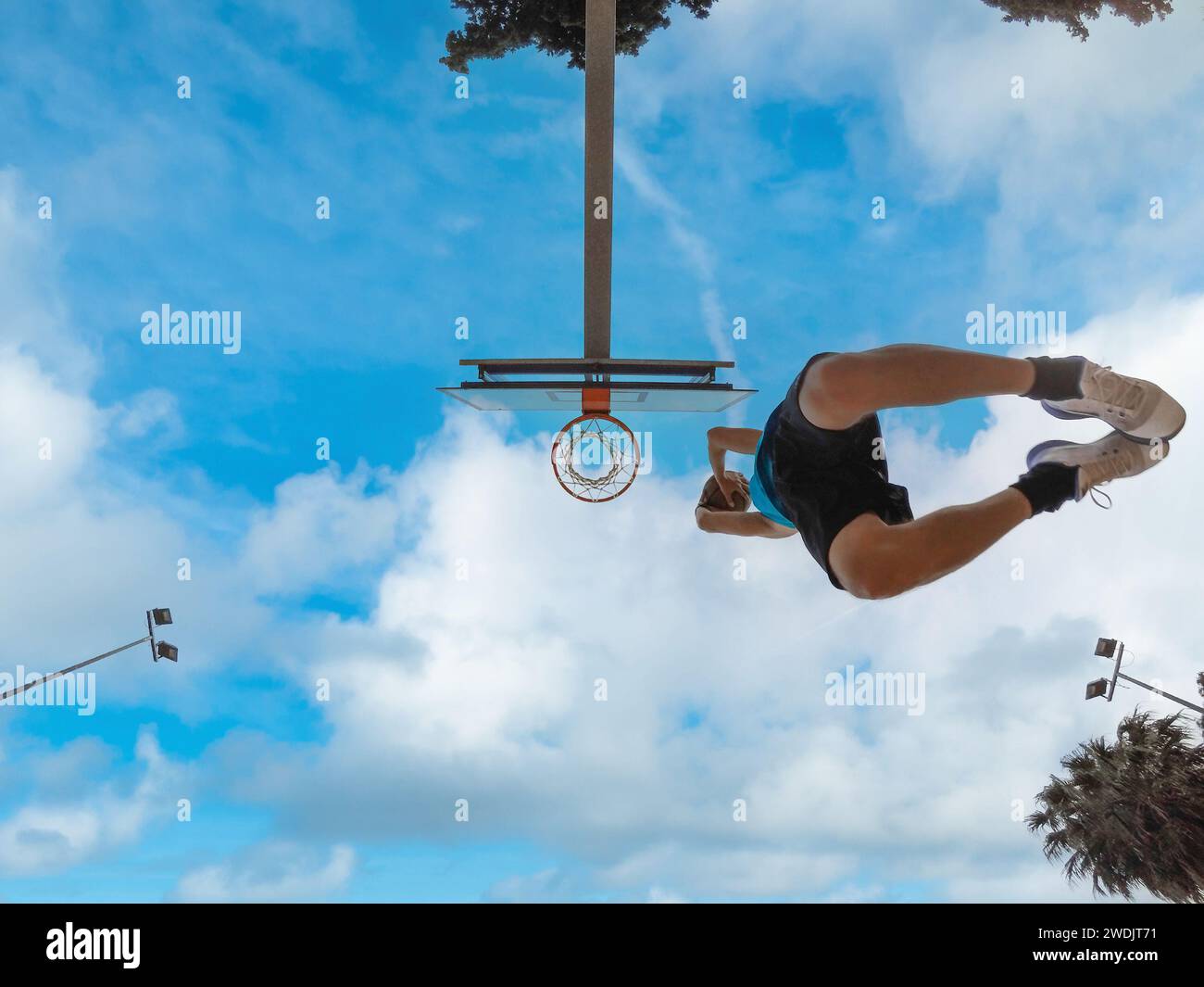Basketball player jumping to the hoop seen from the ground Stock Photo ...
