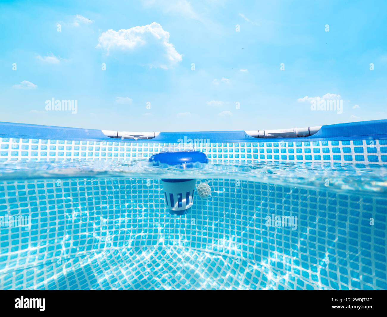 Split underwater view of a chlorine floater dispenser in a pool under a ...
