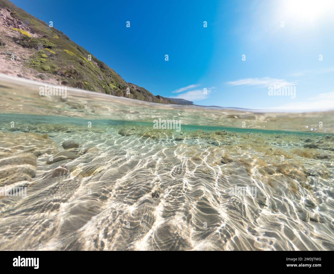 Split underwater view of La Speranza sandy seabed under a shining sun ...