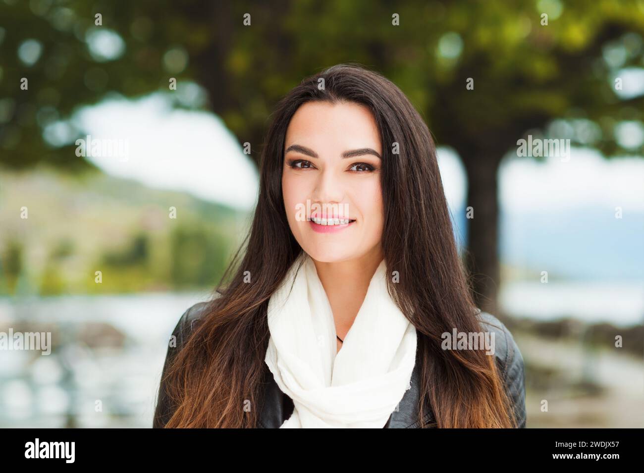 Outdoor Portrait Of Beautiful Brunette Woman With Long Hair Wearing