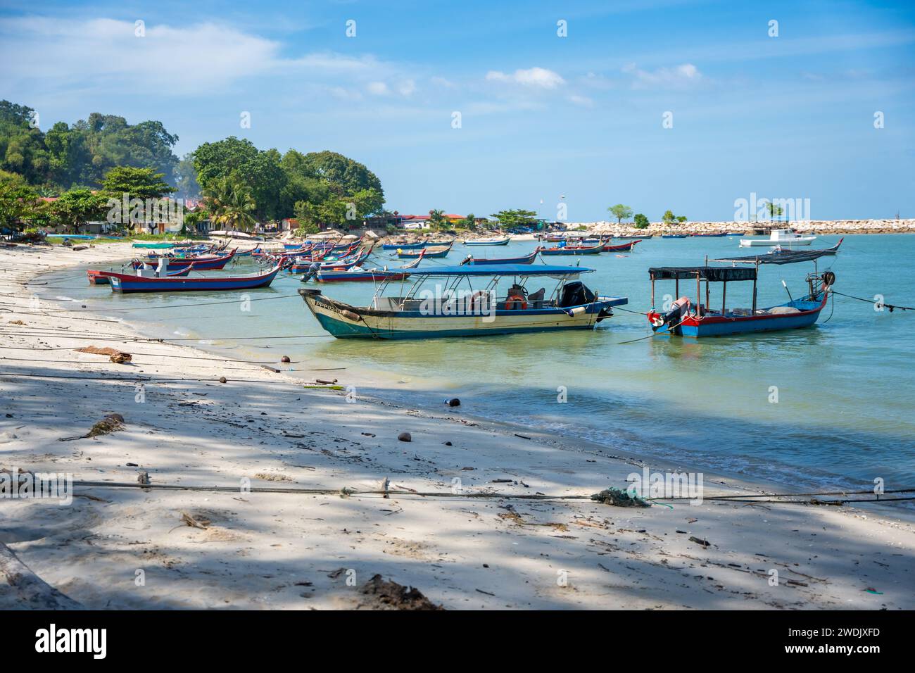 Fishing boats on the sea and beach of George Town city in the distance ...