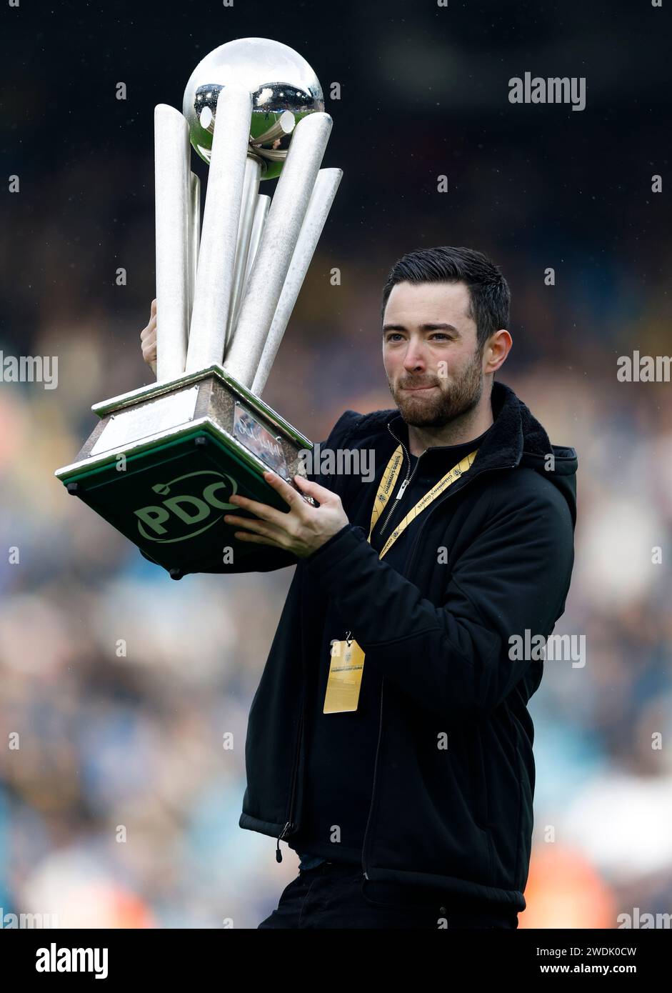 Luke Humphries and his PDC World Darts Championship trophy on the pitch ...