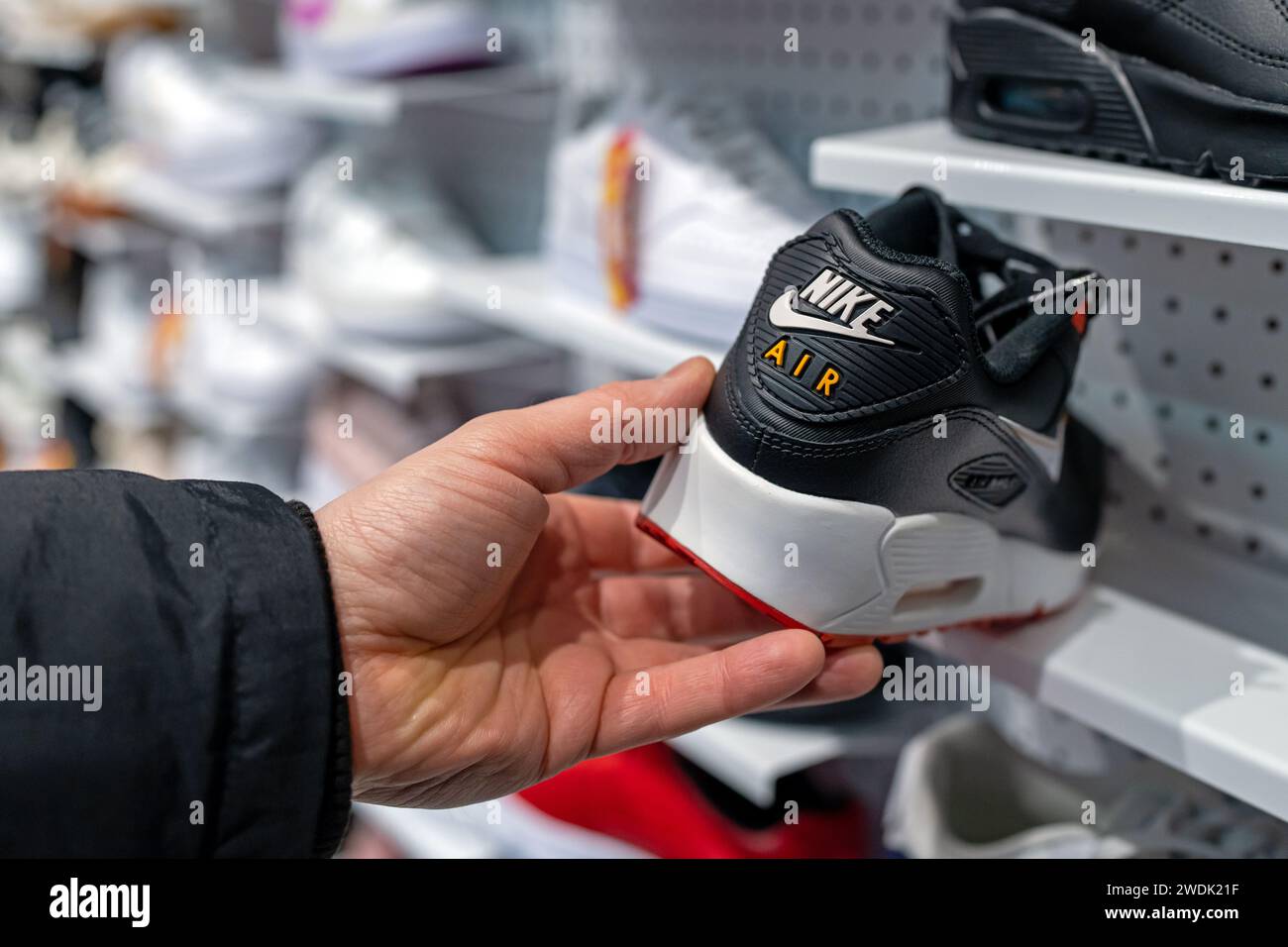 Nike Air sneakers on sports store shelf. Hands of shoppers holding a ...