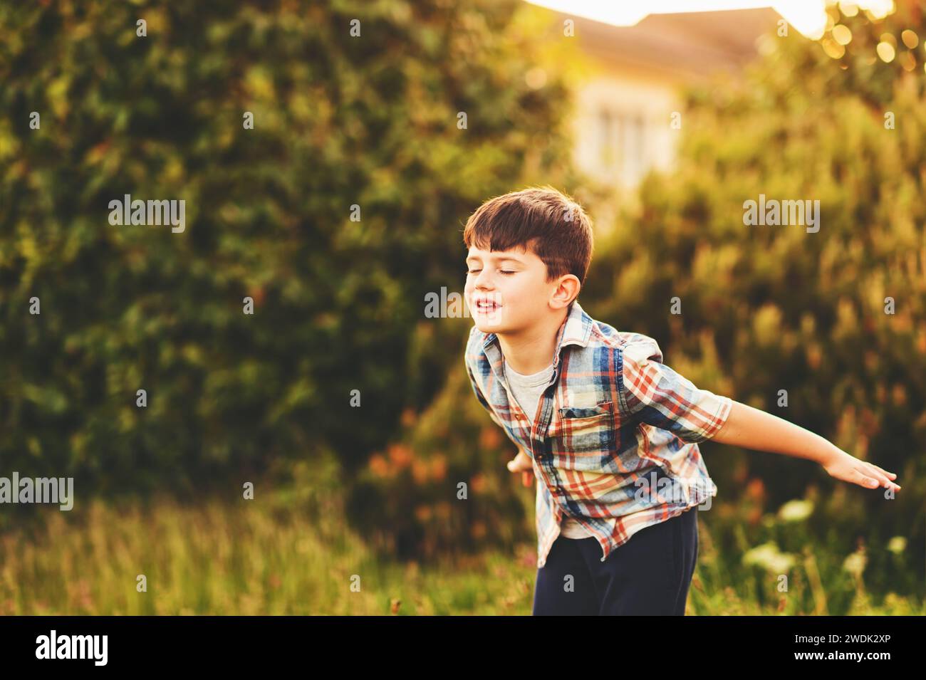 Happy kid boy of 6 year old having fun outdoors wearing blue plaid ...