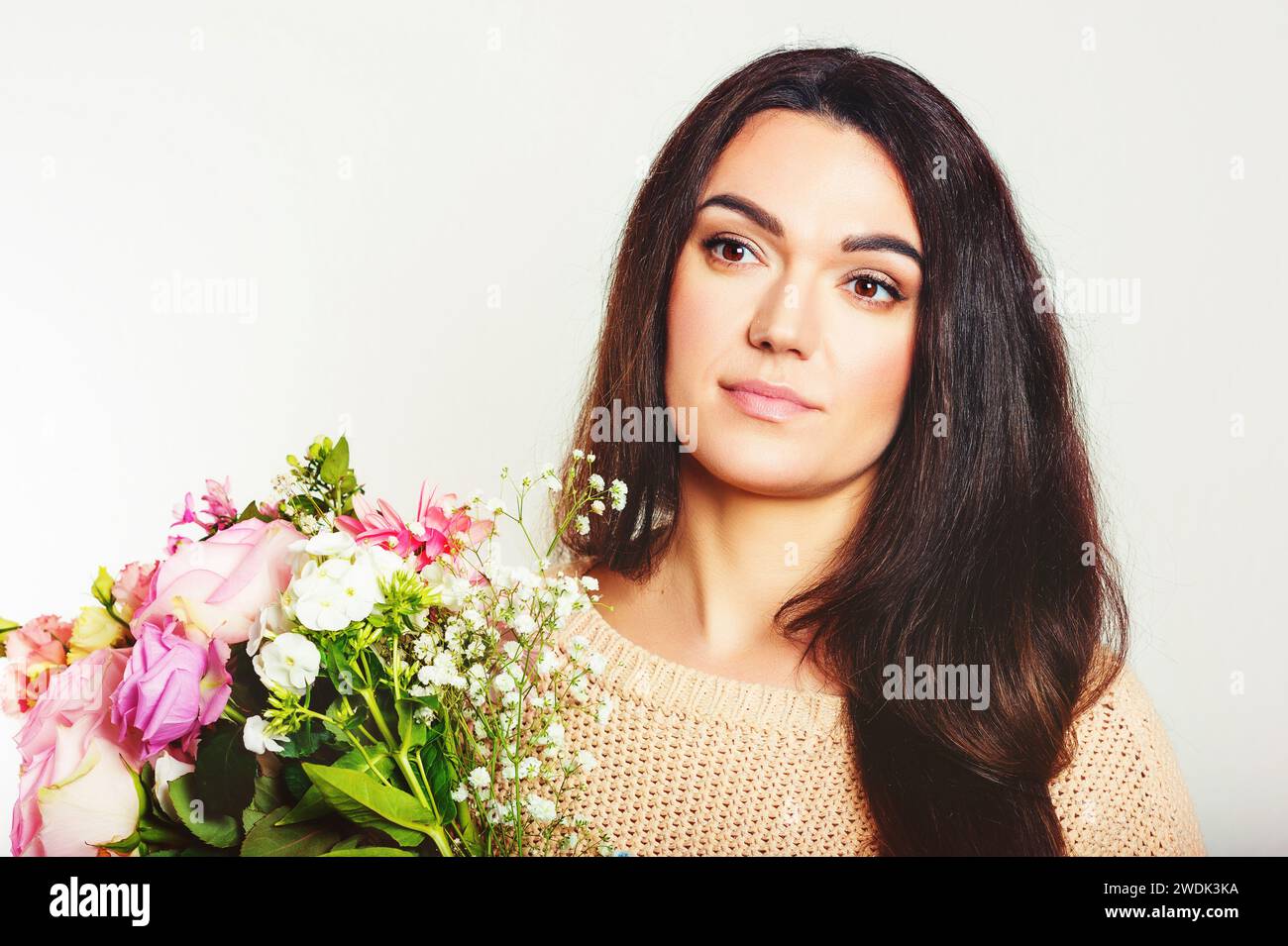 Close up portrait of 35-40 year old woman with black hair, holding big ...