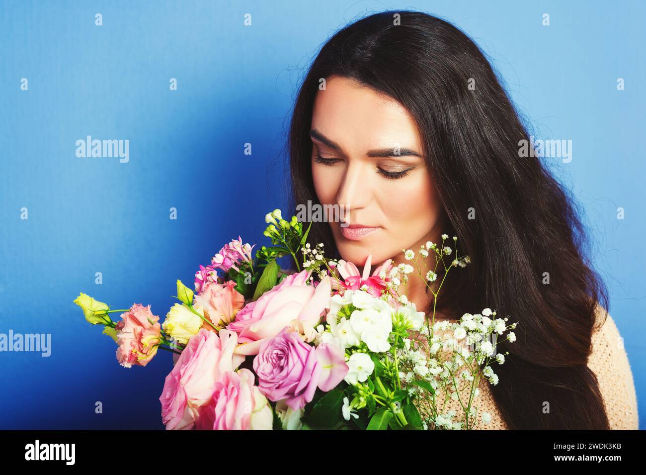 Close up portrait of 35-40 year old woman with black hair, holding big ...